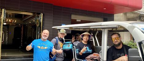 Um grupo de pessoas em frente a um prédio com uma placa que diz 'Wasaki Hotel'.