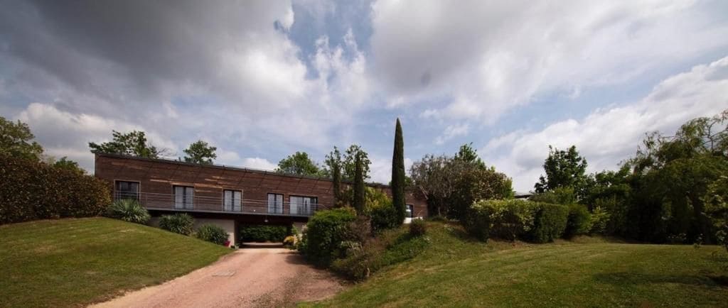 Uma casa moderna de dois andares com um caminho de paralelepípedos que leva a uma garagem.