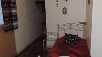 Um quarto com uma cama, um espelho e um objeto decorativo na parede.