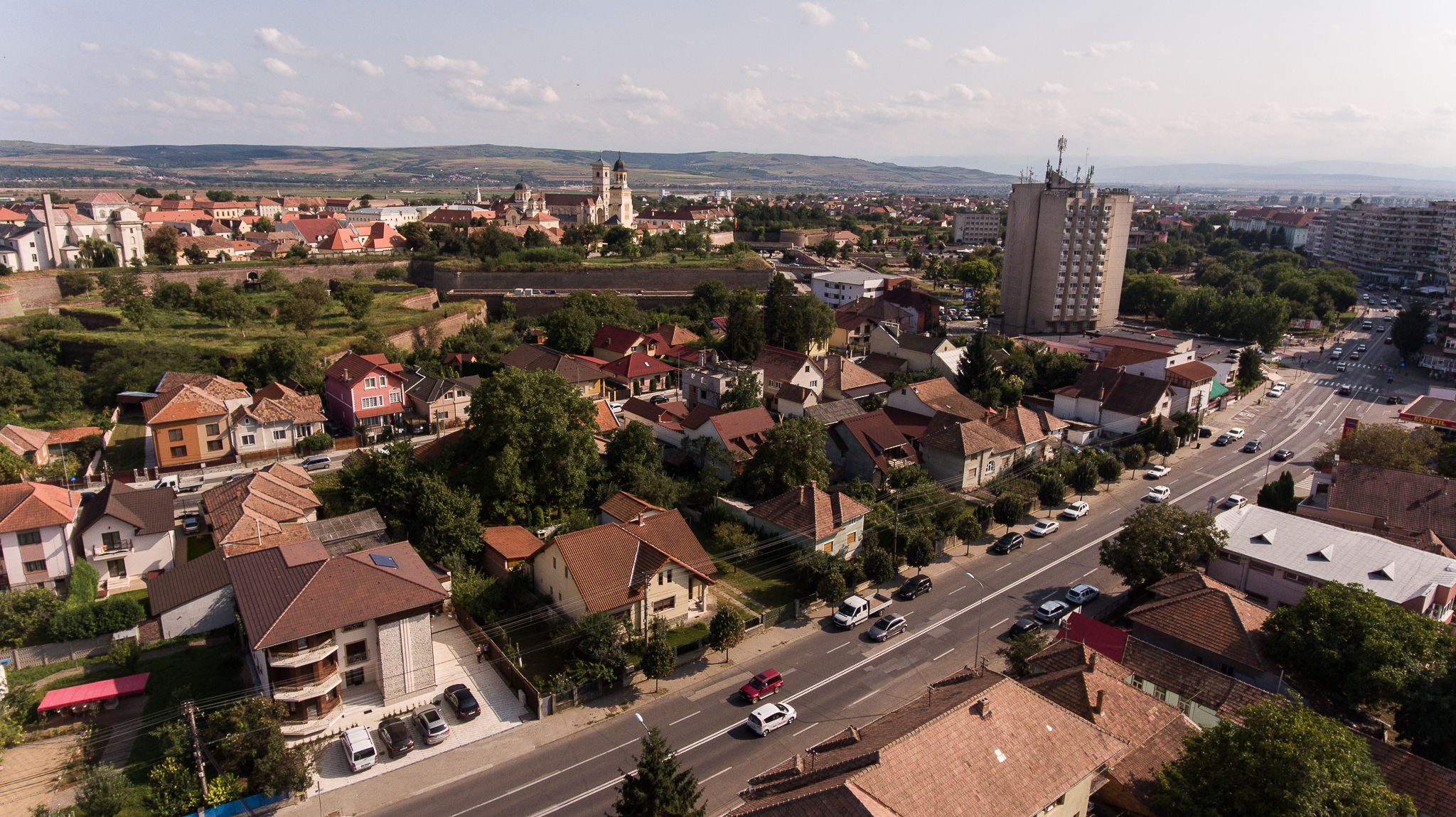 Zona residencial com casas variadas e uma igreja imponente com um campanário.