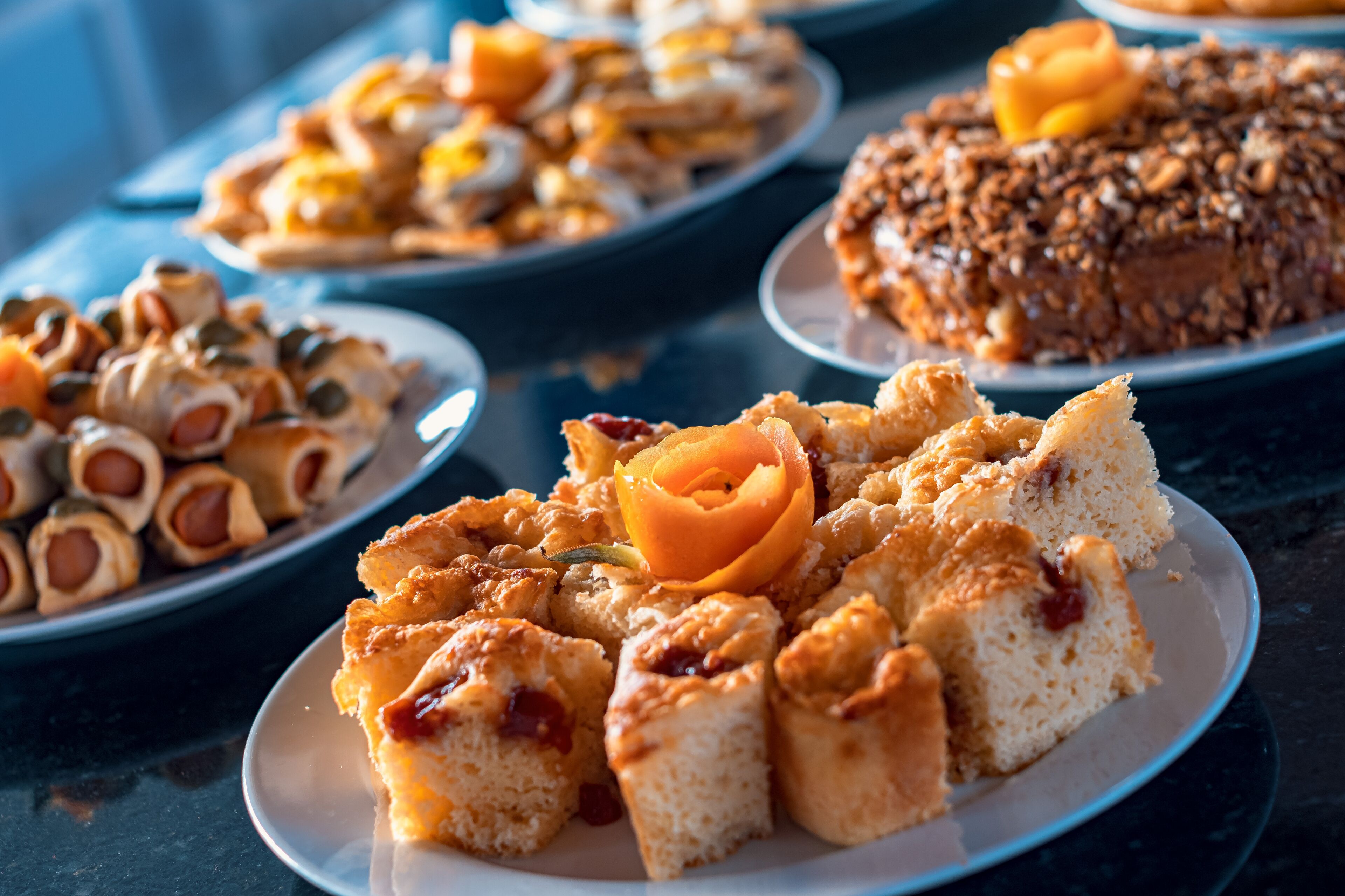 Diversos doces em pratos, incluindo bolos e pasteis.