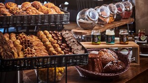 Buffet com diversos produtos de pastelaria e potes de acompanhamentos.