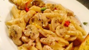 Um prato de massa com cogumelos e legumes.