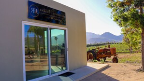 Um edifício com porta de vidro e placa com a inscrição 'RANCHOS LOS RETONOS VALLE DE QUADALUPE'.