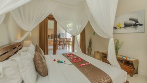 Quarto com cama, cortinas brancas, cabeceira de madeira, mesa de cabeceira e um quadro na parede.