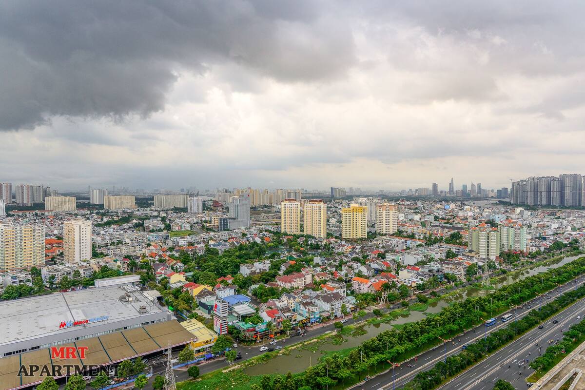 Paisagem urbana com edifícios altos, um rio e uma autoestrada.