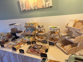 Um buffet de café da manhã com diversos alimentos e etiquetas.
