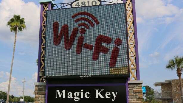 Placa de hotel com símbolo de Wi-Fi, símbolo de chave e o nome 'Magic Key'.