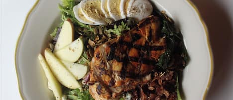 Prato com frango grelhado, fatias de maçã e salada.