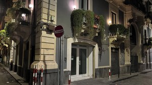 Um edifício histórico com porta fechada, placa de 'proibido entrar' e aviso de 'propriedade privada'.
