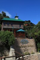 Um edifício de pedra com telhado verde e uma placa com a inscrição 'Boardwalk Lodge'.
