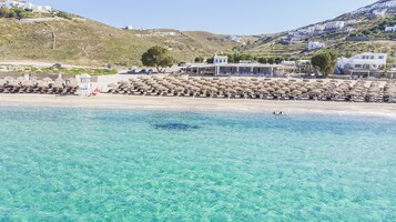 Na praia, praia de areia branca, espreguiçadeiras, guarda-sóis de praia 