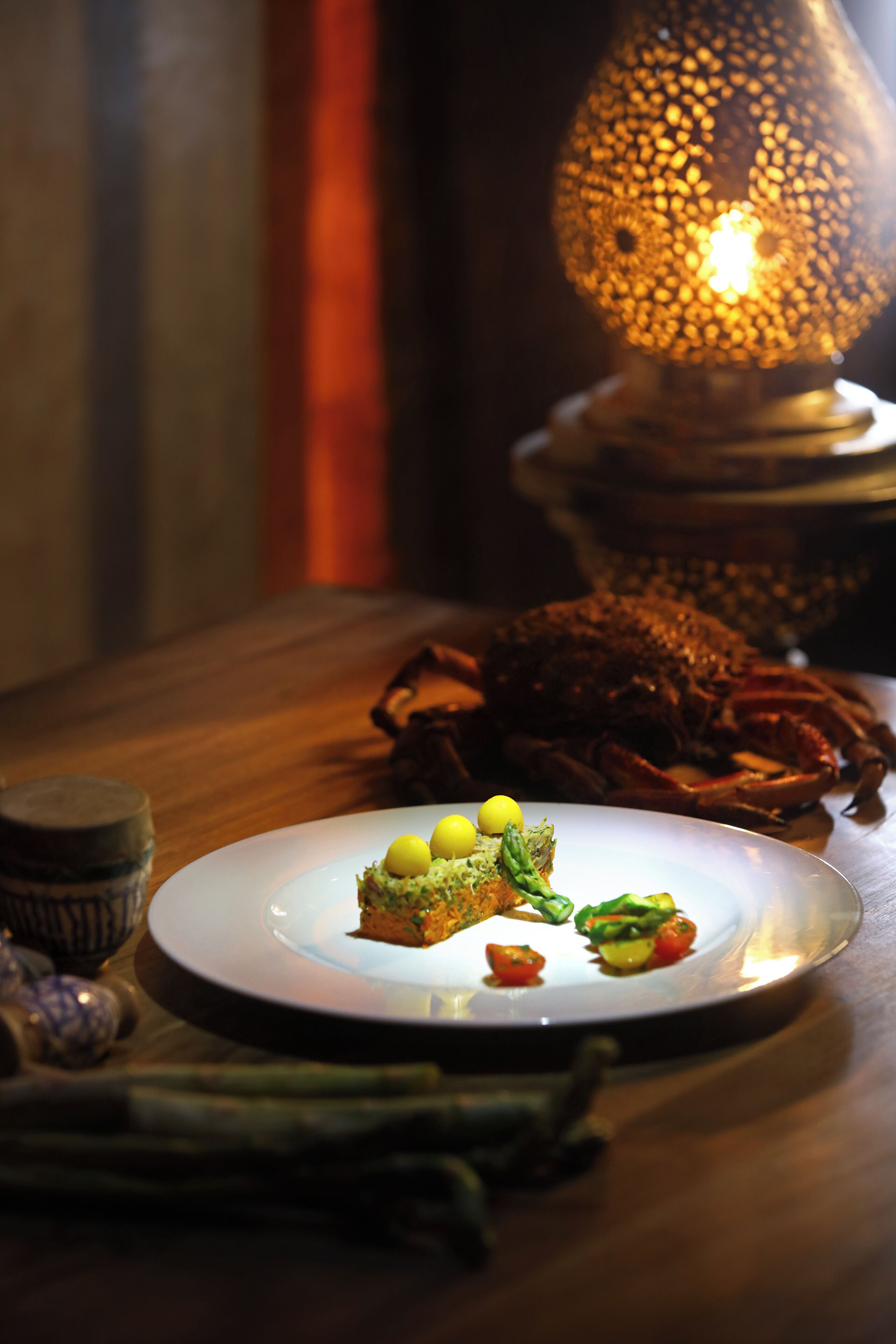 Prato de comida com uma luminária decorativa ao fundo.