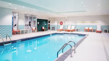 Piscina com espreguiçadeiras e vestiário.