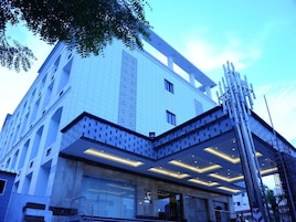 Um edifício moderno com uma coluna vertical marcante, grandes janelas e fachada com padrão.