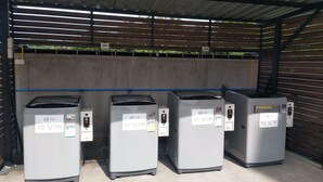 Quatro contentores industriais com etiquetas a indicar a sua capacidade em litros, dispostos sob uma estrutura metálica.