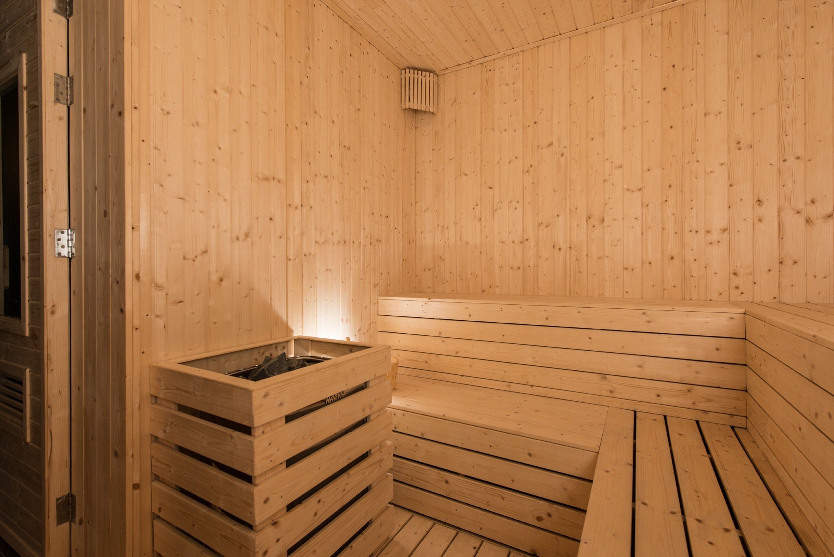 Uma sauna de madeira com bancos e um assento de madeira.