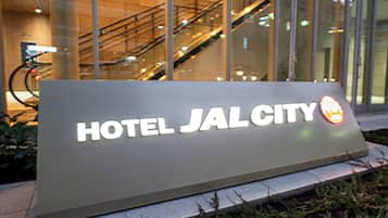 Placa do Hotel Jalcity com design moderno e uma escadaria visível ao fundo.