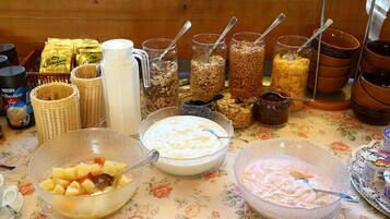 Um buffet de café da manhã com diversos alimentos e recipientes.