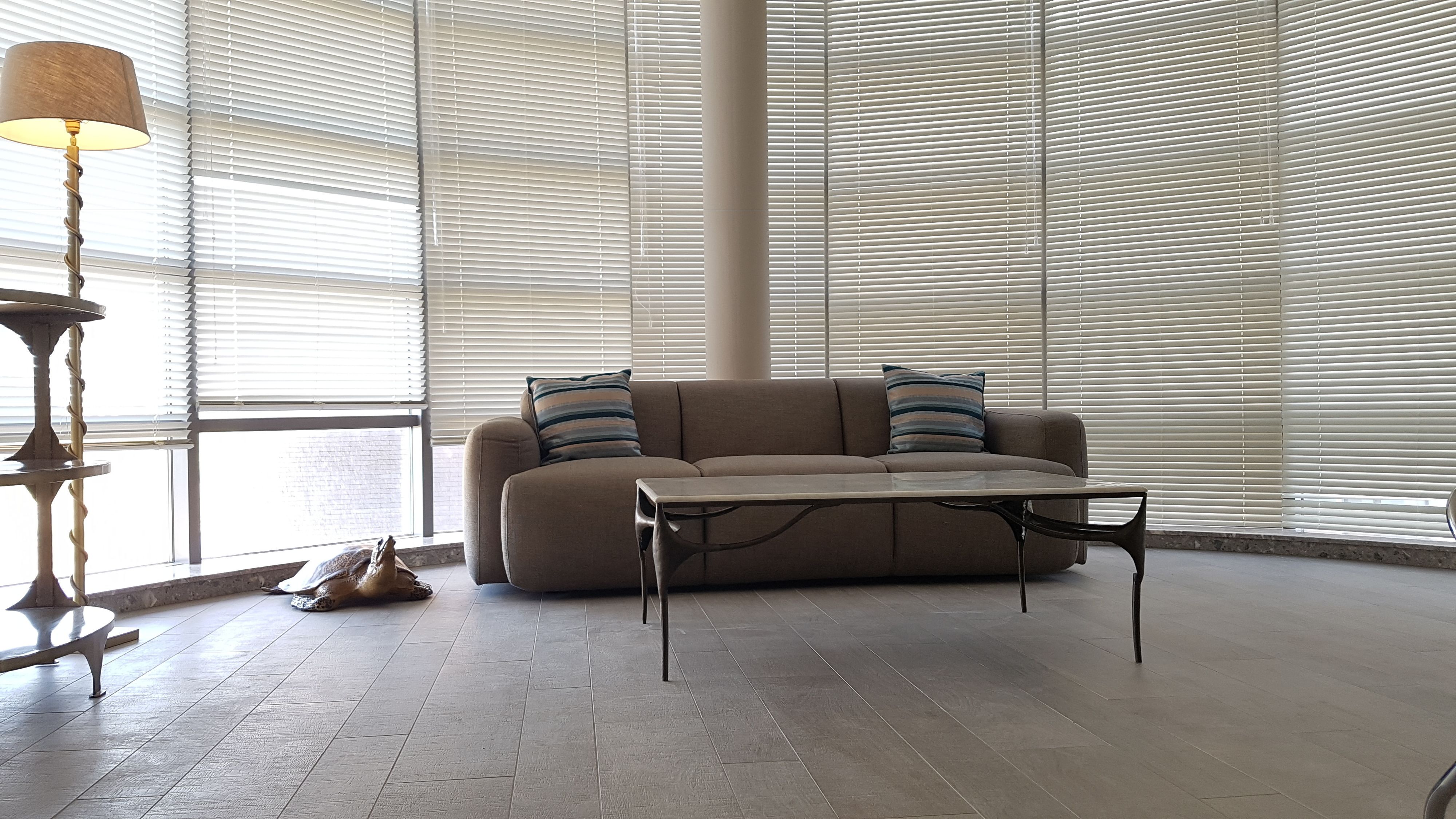 Uma sala de estar moderna com um sofá, uma mesa de centro e uma luminária.