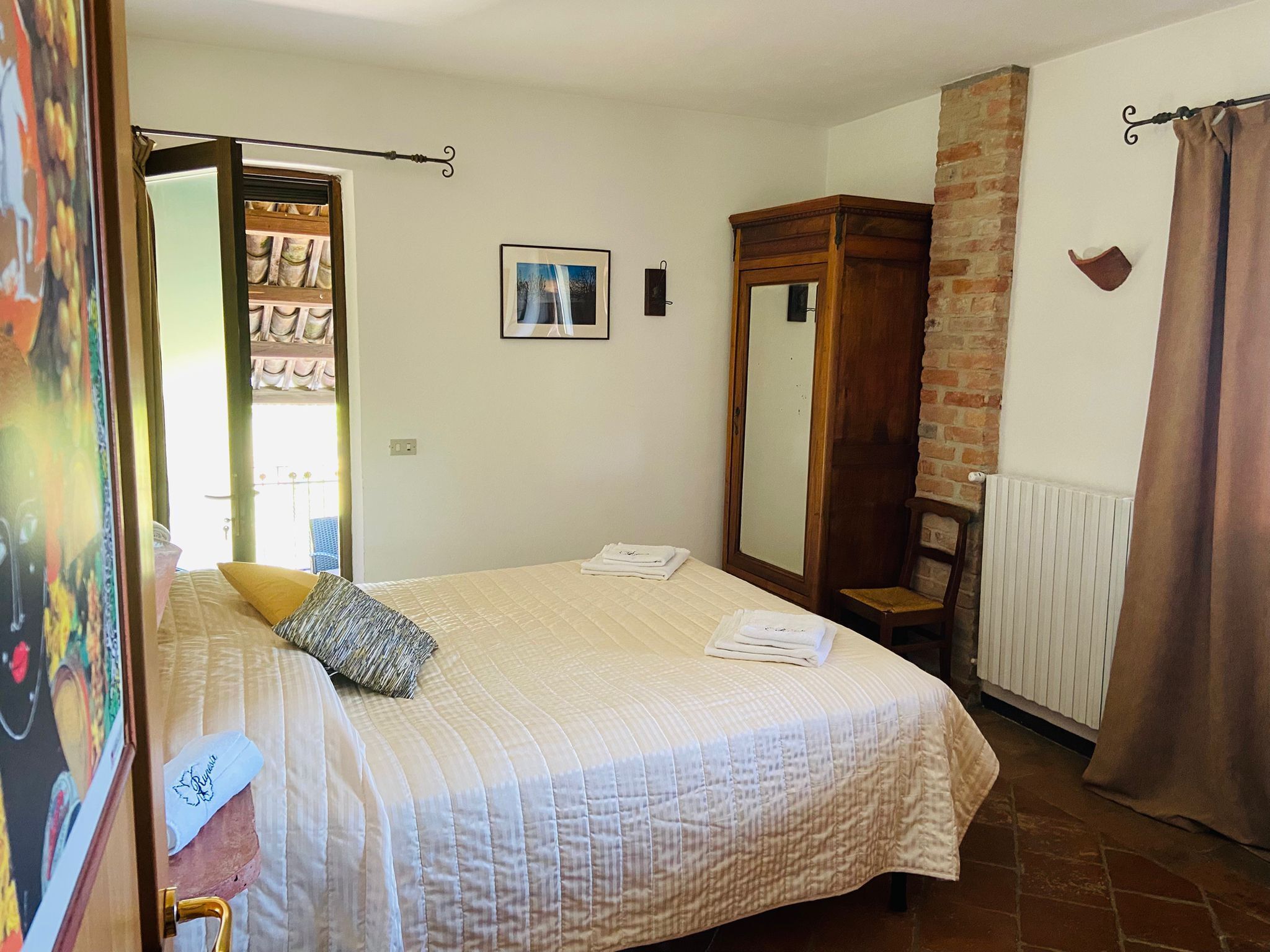 Quarto com cama, guarda-roupa, espelho e radiador.