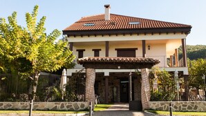 Um edifício de dois andares com telhado em telhas e entrada de pedra.