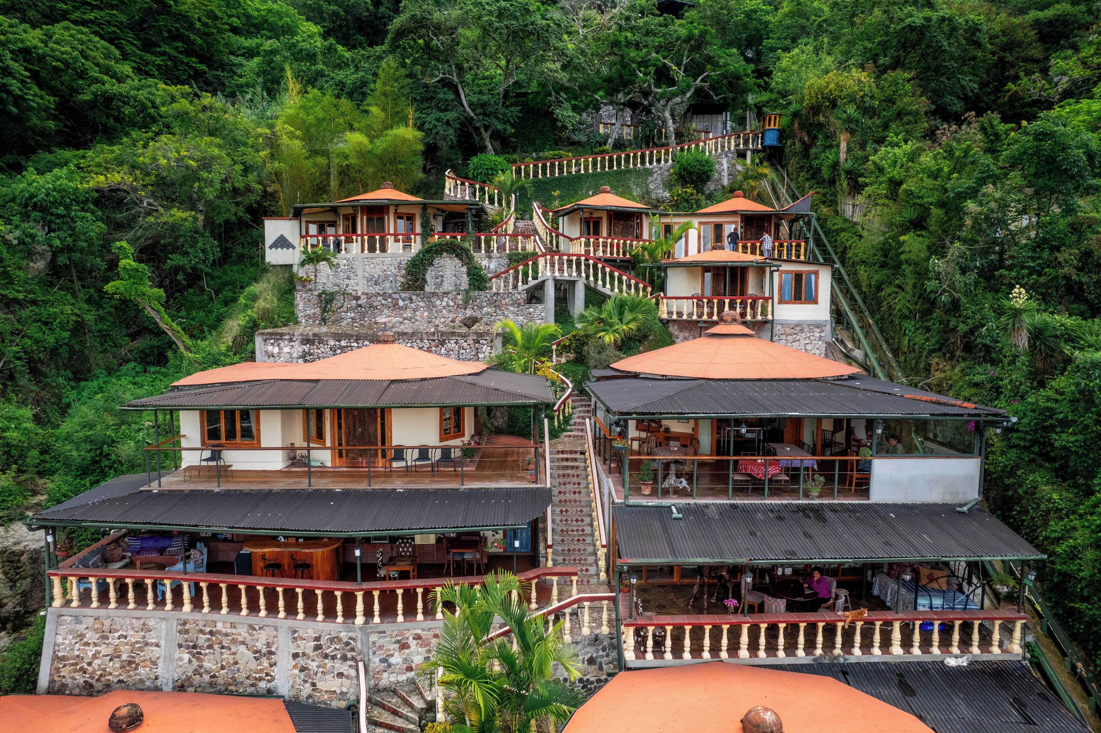 Hotel numa encosta com vários edifícios, cada um com varanda e zona de refeições.