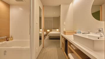 Uma casa de banho de hotel moderna com uma banheira grande, uma pia e um espelho.