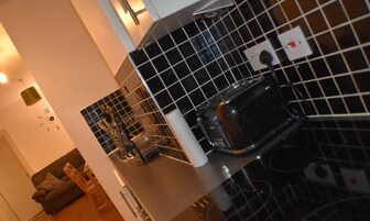 Apartamento, 2 quartos | Cozinha privada | Geladeira grande, micro-ondas, fogão, cooktop