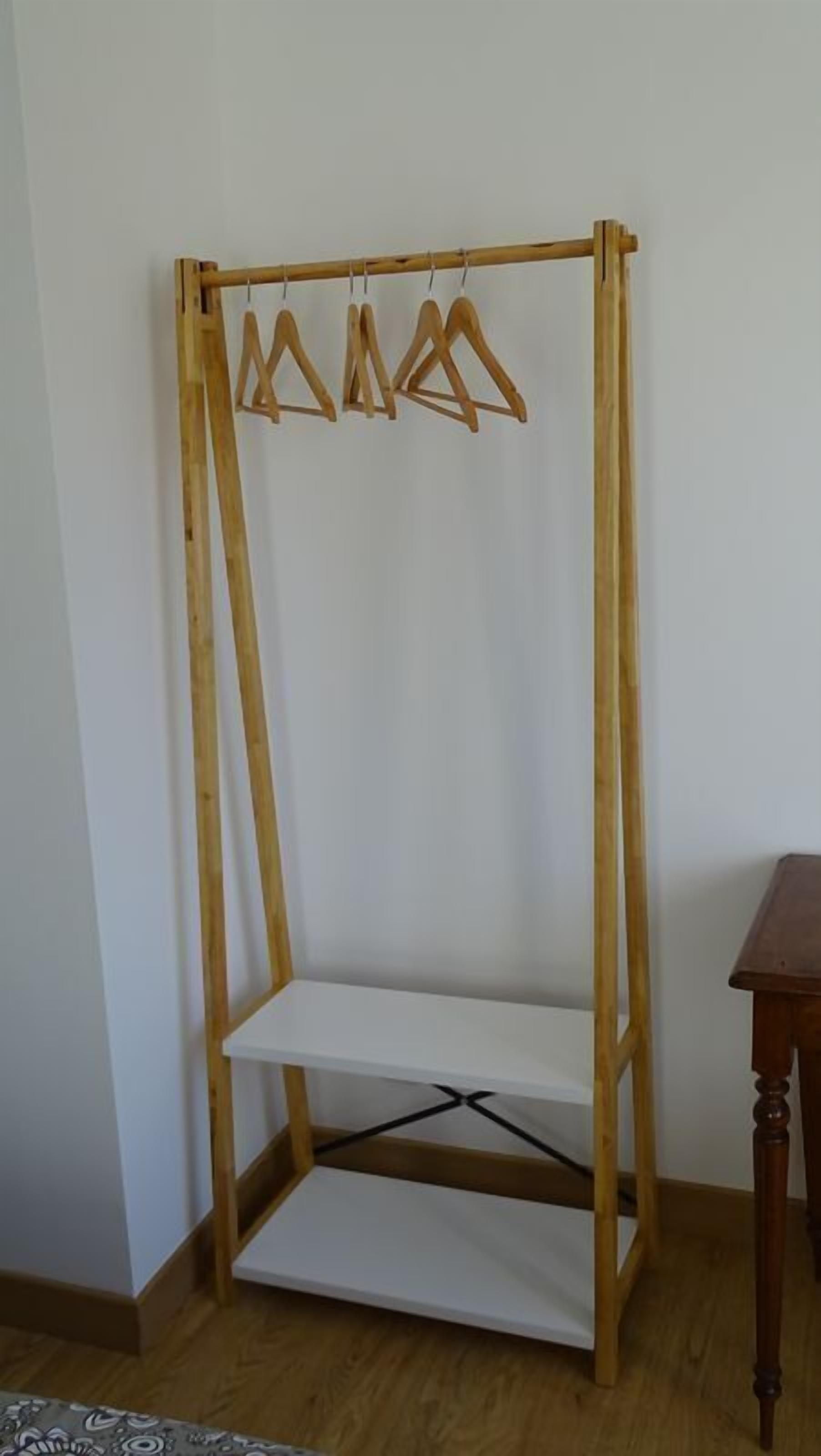 Um guarda-roupa de madeira com duas prateleiras e uma barra para pendurar roupas.