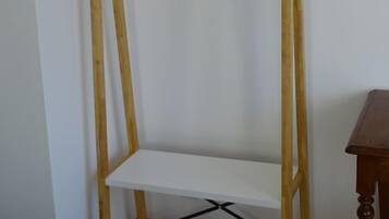 Um guarda-roupa de madeira com duas prateleiras e uma barra para pendurar roupas.