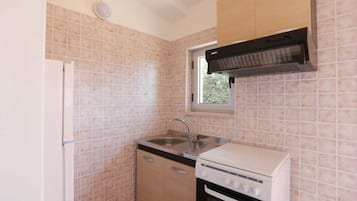 Bungalow Básico, 1 cama queen-size | Kitchenette privada | Um frigorífico, um forno, uma placa de cozinha, utensílios de cozinha