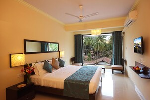 Quarto de hotel com cama, mesa de cabeceira e vista para o exterior.