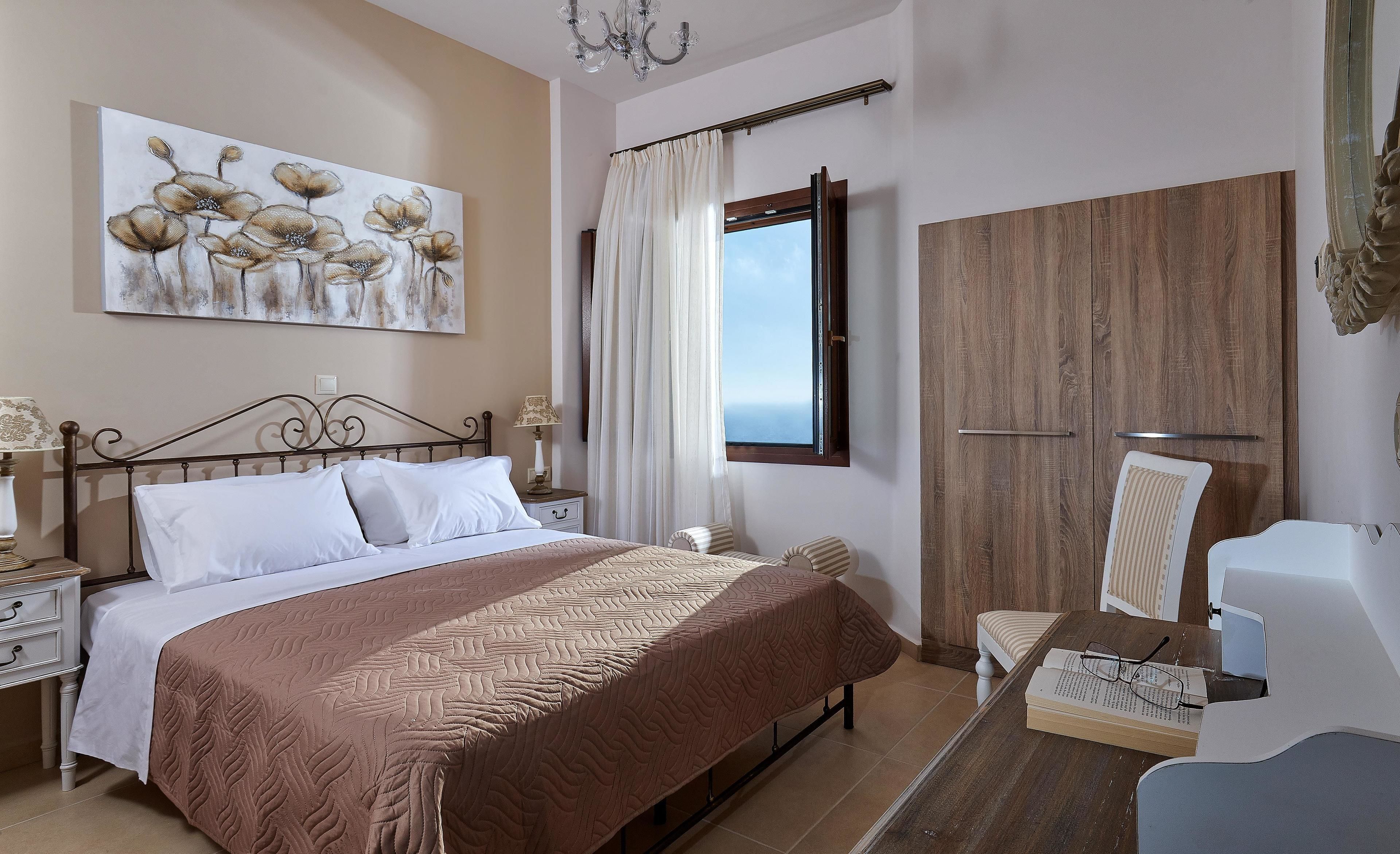 Quarto com cama, mesas de cabeceira, guarda-roupa, janela com cortinas e um quadro na parede.