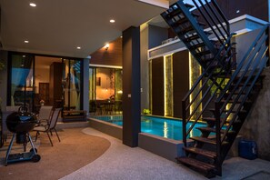 Um interior moderno com piscina, área de estar externa e escadaria.