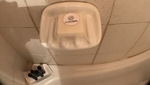 Casa de banho com dispensador de sabonete fixado na parede.