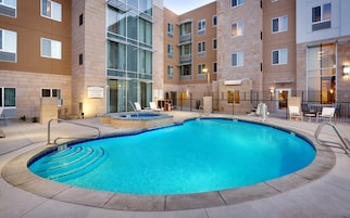 Hotel com piscina, vários andares e aviso de ausência de salva-vidas.