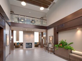 Um hall amplo com lareira, área de estar e um mezanino.