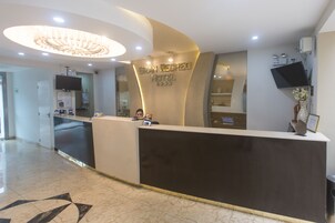 Uma receção de hotel com design moderno, um candelabro e uma placa que diz "GRAN RECREO HOTEL".