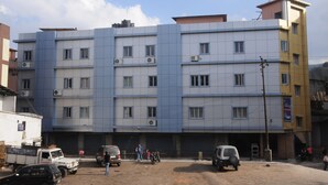 Um edifício de vários andares com fachada plana, várias janelas e aparelhos de ar condicionado.