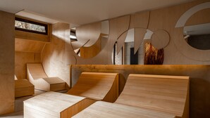Uma área de spa moderna com bancos de madeira e um amplo painel de espelhos.