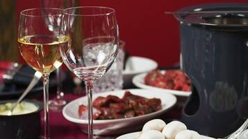 Uma mesa de jantar com copos de vinho, um bule quente e diversos pratos.