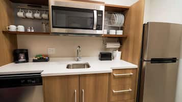 Um frigorífico/congelador grande, um micro-ondas, uma placa de cozinha