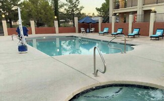 Piscina com espreguiçadeiras e área de hidromassagem.