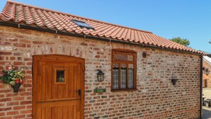 Um edifício de tijolos com porta de madeira e janela.