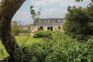 Uma casa de dois andares com um jardim frontal.