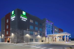 Um hotel Holiday Inn Express com design moderno, fachada em pedra e entrada ampla.