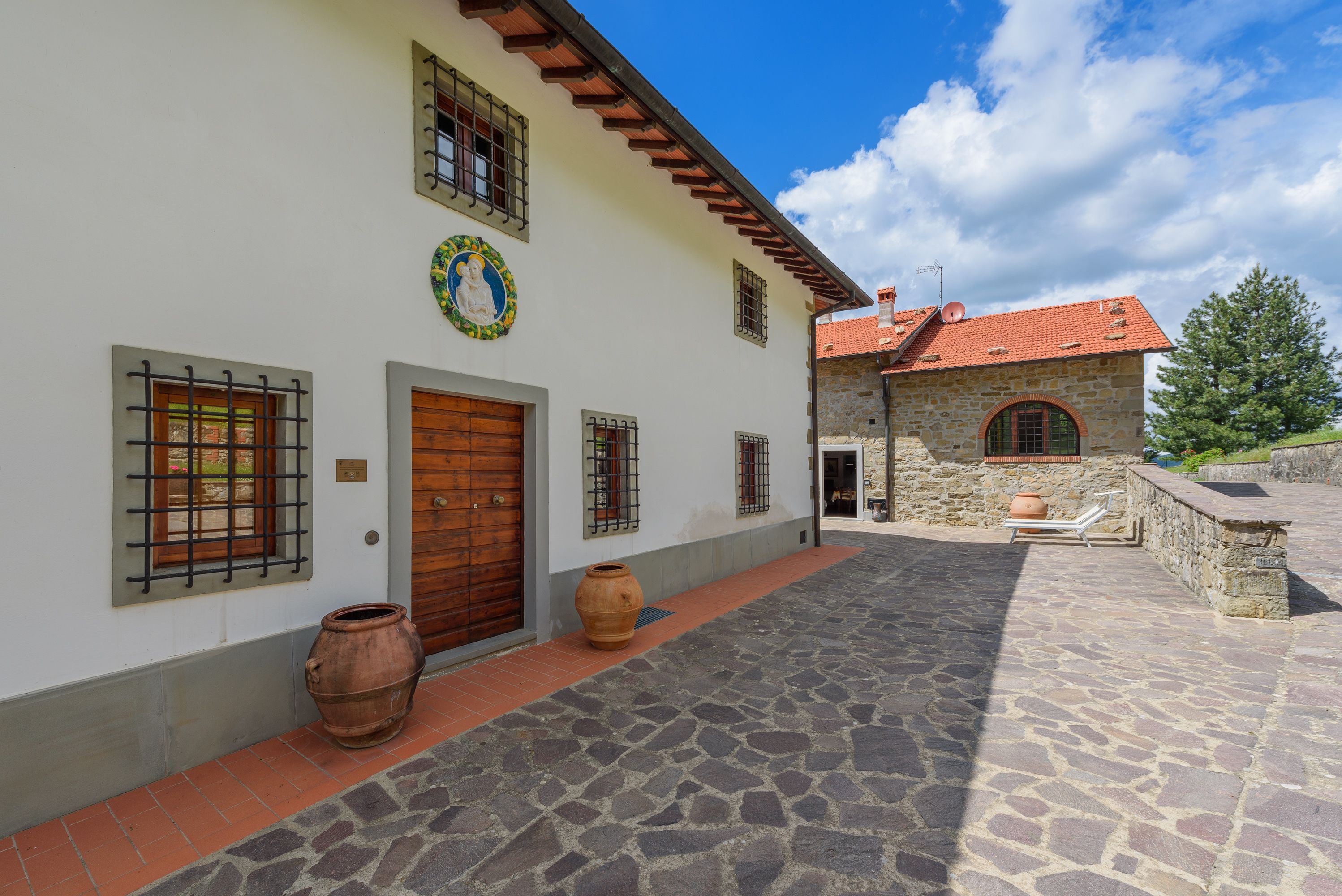 Um edifício com fachada de pedra, porta de madeira e telhado de telhas.