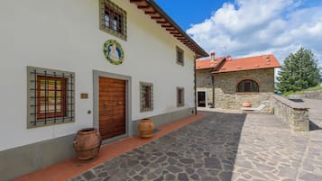 Um edifício com fachada de pedra, porta de madeira e telhado de telhas.