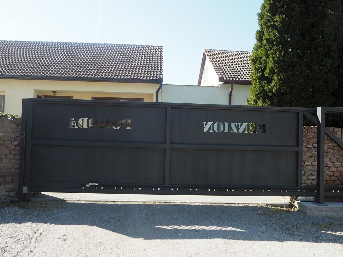 Uma entrada fechada por portão com as palavras "AOTTO" e "YONOV" escritas no portão.